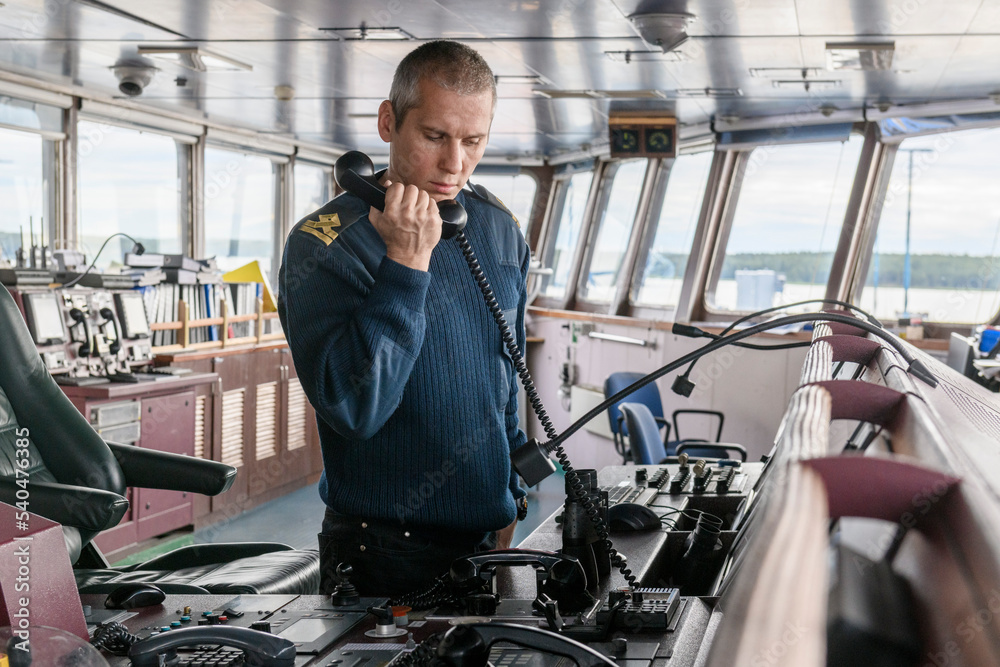 Deck officer on watch during cargo operations. Man in white overall ...