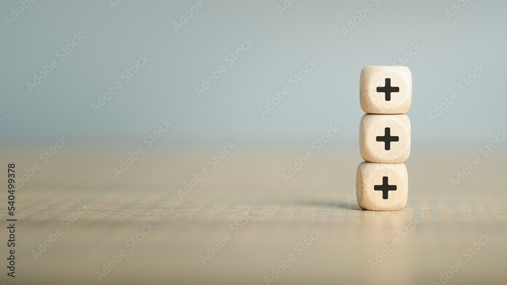 Plus sign in wooden cube block stacking. Addition and positive mindset ...
