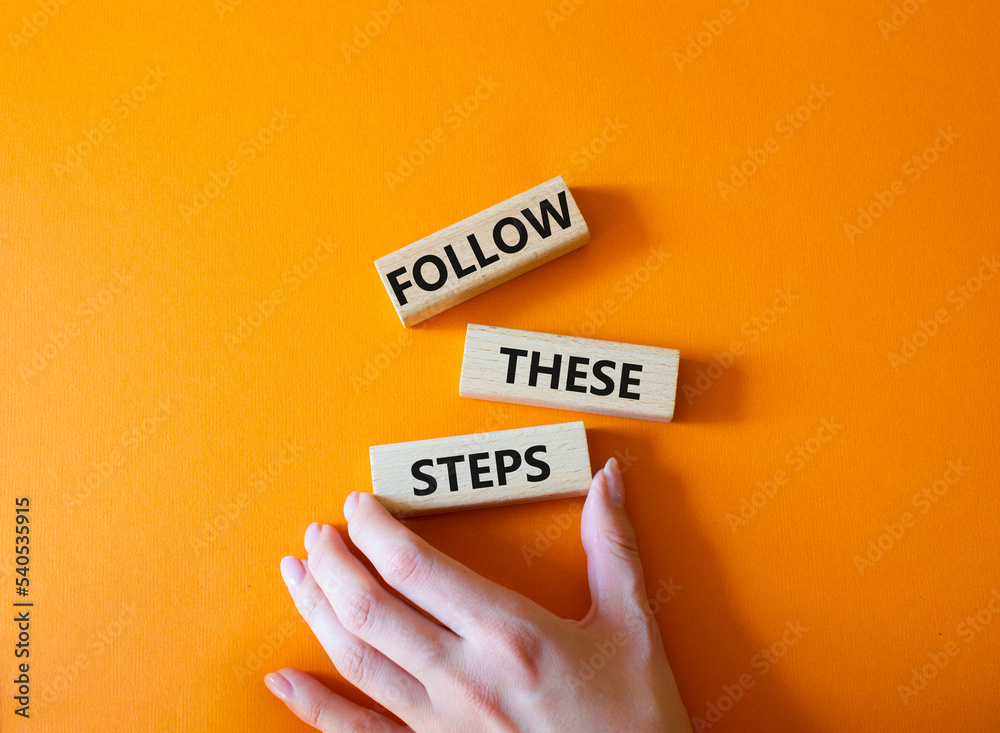 Follow these steps symbol. Wooden blocks with words Follow these steps. Beautiful orange ...