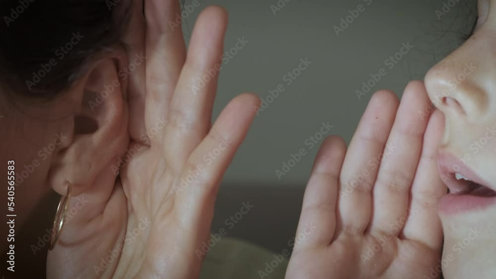 Telling secret to mum ear indoor. A view of mother with her daughter ...