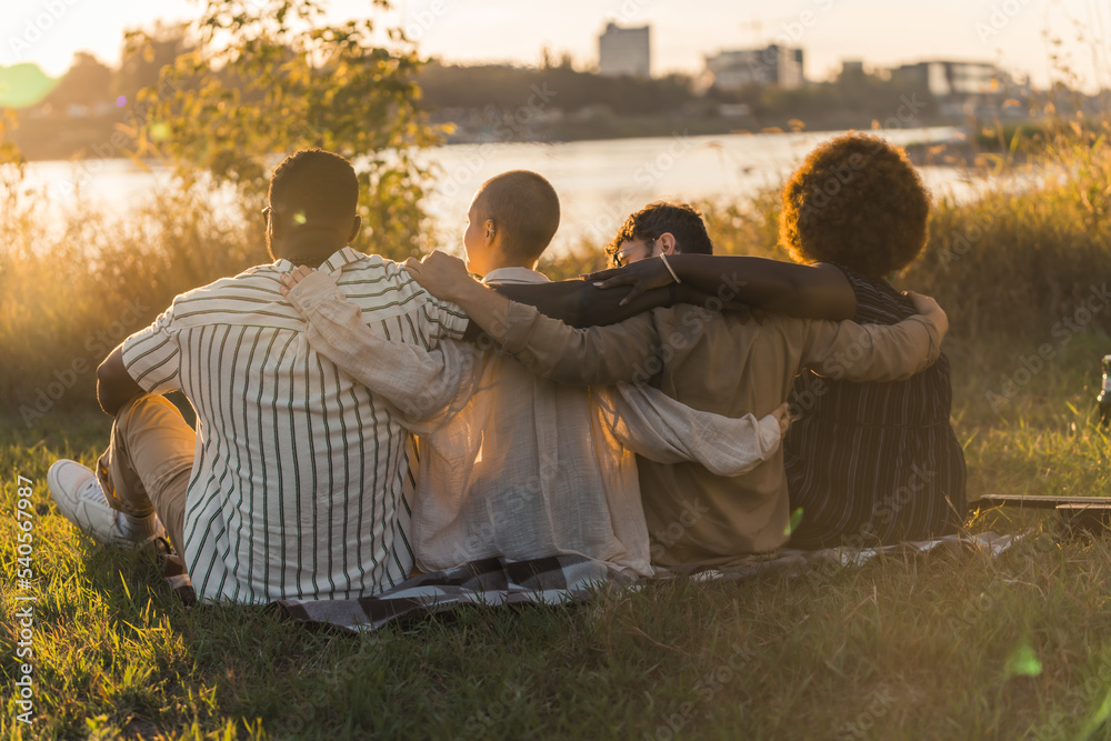 Beauty of friendship bond. Outdoor shot. Group of people sitting by the ...