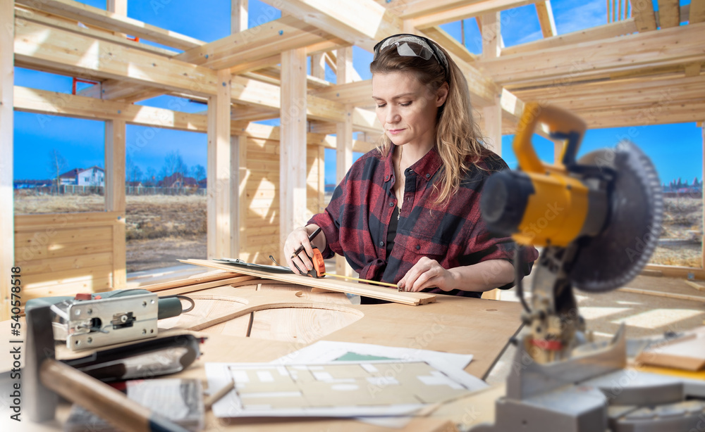 Woman carpenter. Girl is involved in construction of house. Woman in ...