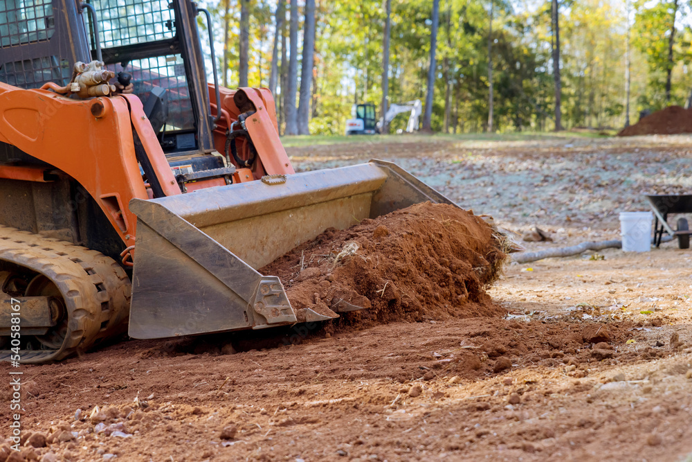 Small tractor is used for moving soil for landscaping on construction ...