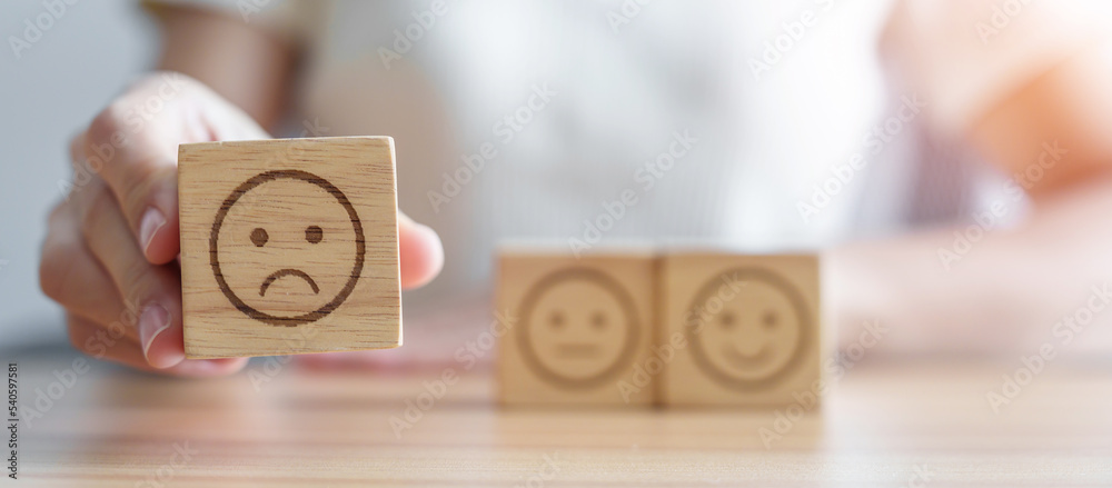 Hand choosing unhappy angry face from Emotion block. customer review ...