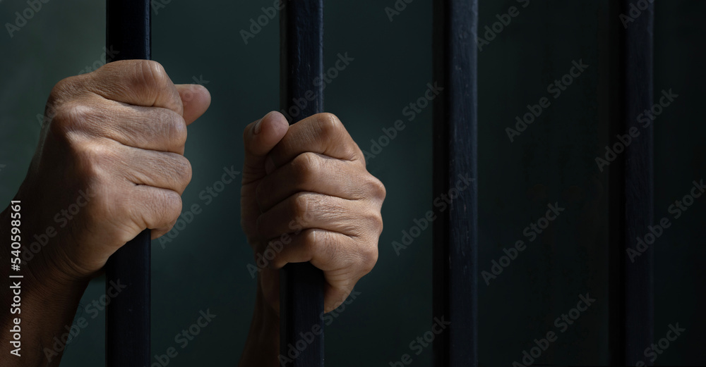 Hand of convicted prisoner behind the cell bar inside jail for ...