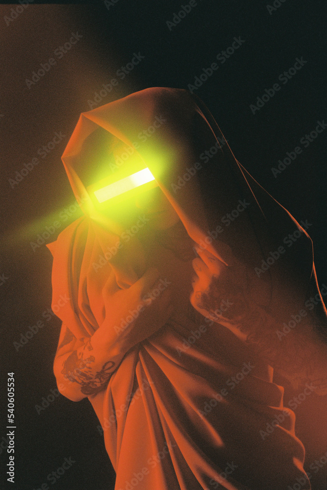 Portrait of man in red mantle with bright light on his face standing ...