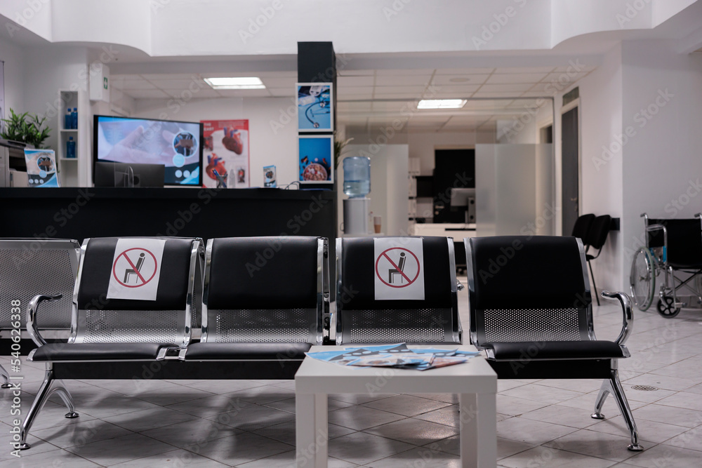 General shot of empty hospital waiting area. Sectioned seats to prevent ...