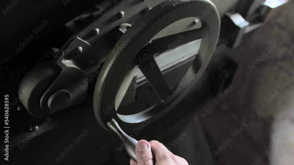 Aiming the sight in a military artillery gun. The soldier's hand twists ...