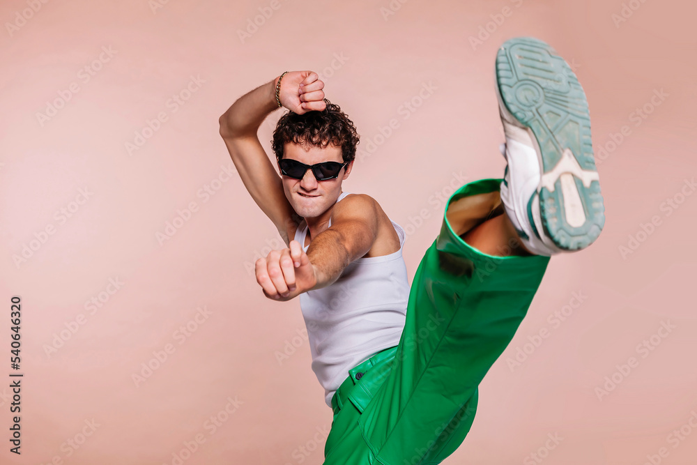 Portrait of handsome guy, throwing high kick in the air, practicing ...