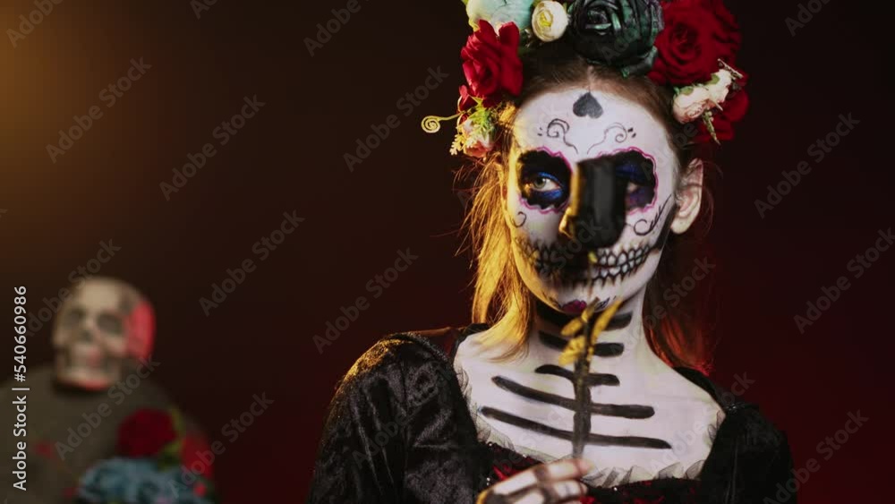 Beautiful model wearing death costume and flowers wreath over studio ...