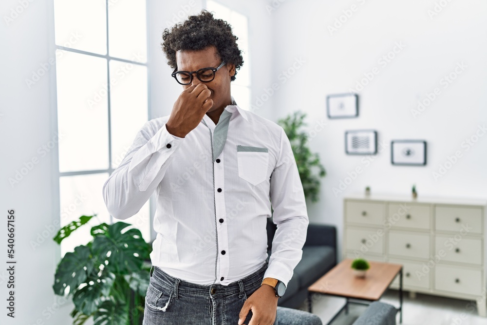 African psychologist man at consultation office smelling something ...