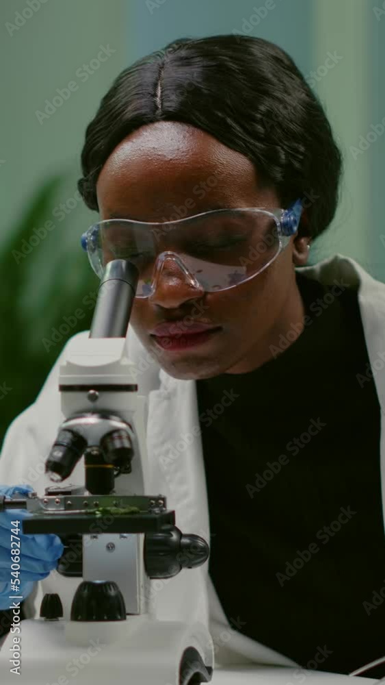 Vertical video: Portrait of scientist taking leaf sample with ...