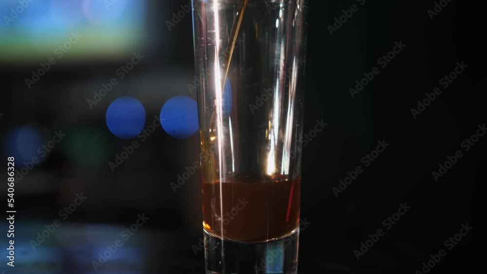 Cocktail Shots. close-up. bartender is pouring different alcoholic drinks in layers, into shot ...