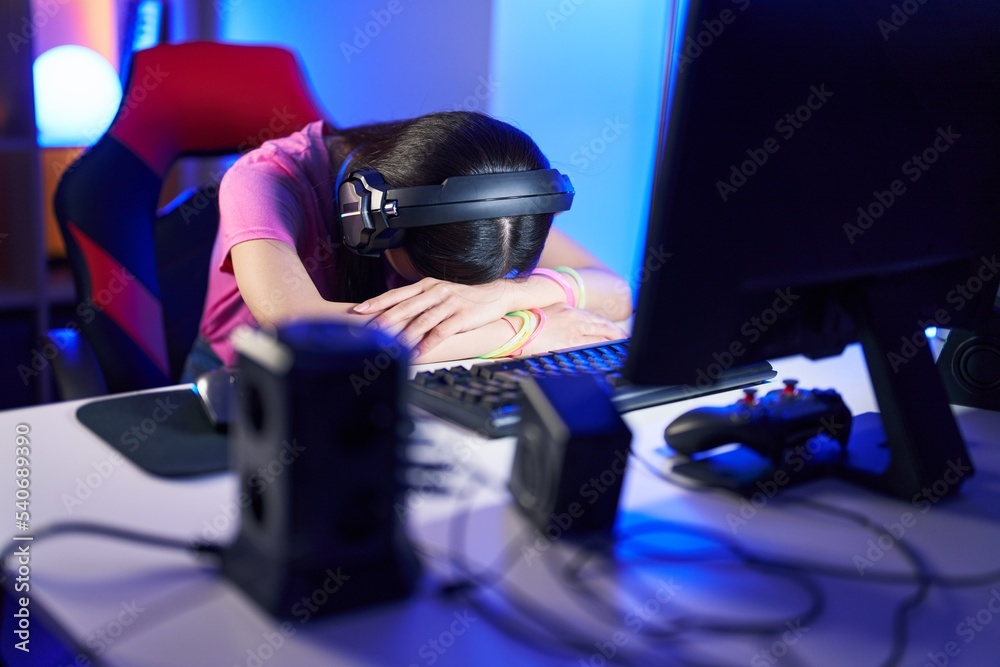 Young chinese woman streamer stressed using computer at gaming room ...