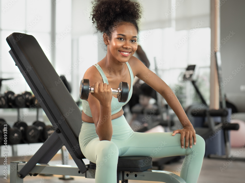 Beautiful athlete woman lifts dumbbell, weight training to strength ...