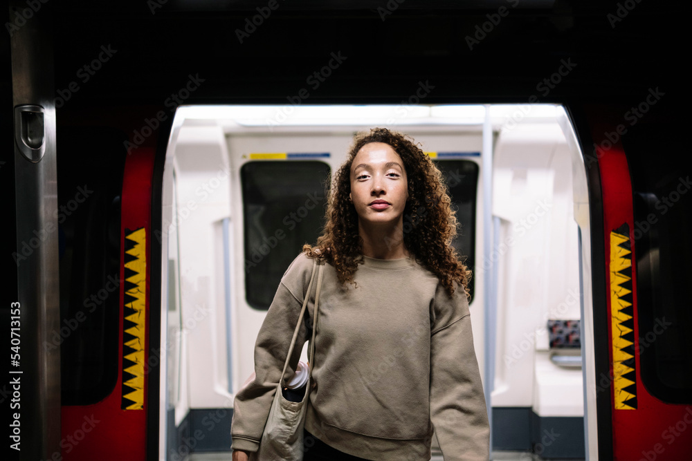 Young woman disembarking from train at subway station Stock Photo ...