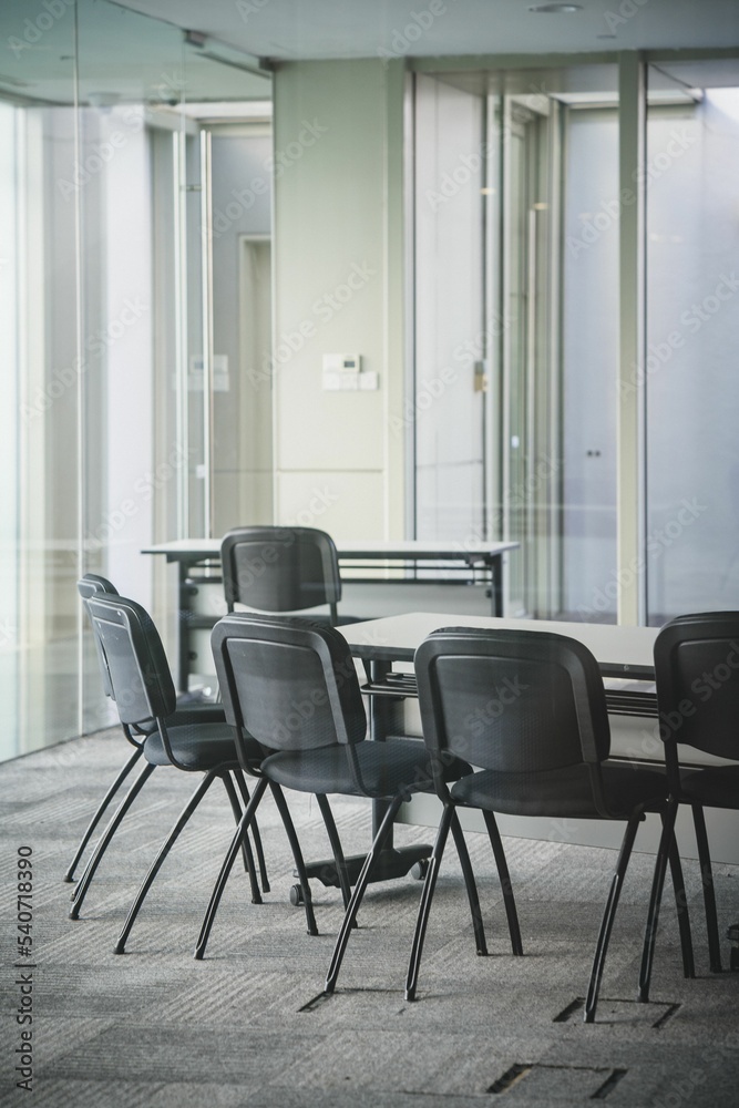Vertical of a modern meeting room set up with white walls and black ...