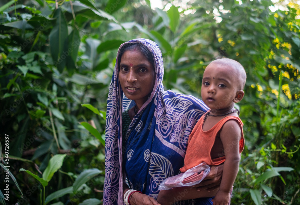 South asian mother holding her son wearing traditional clothes in ...