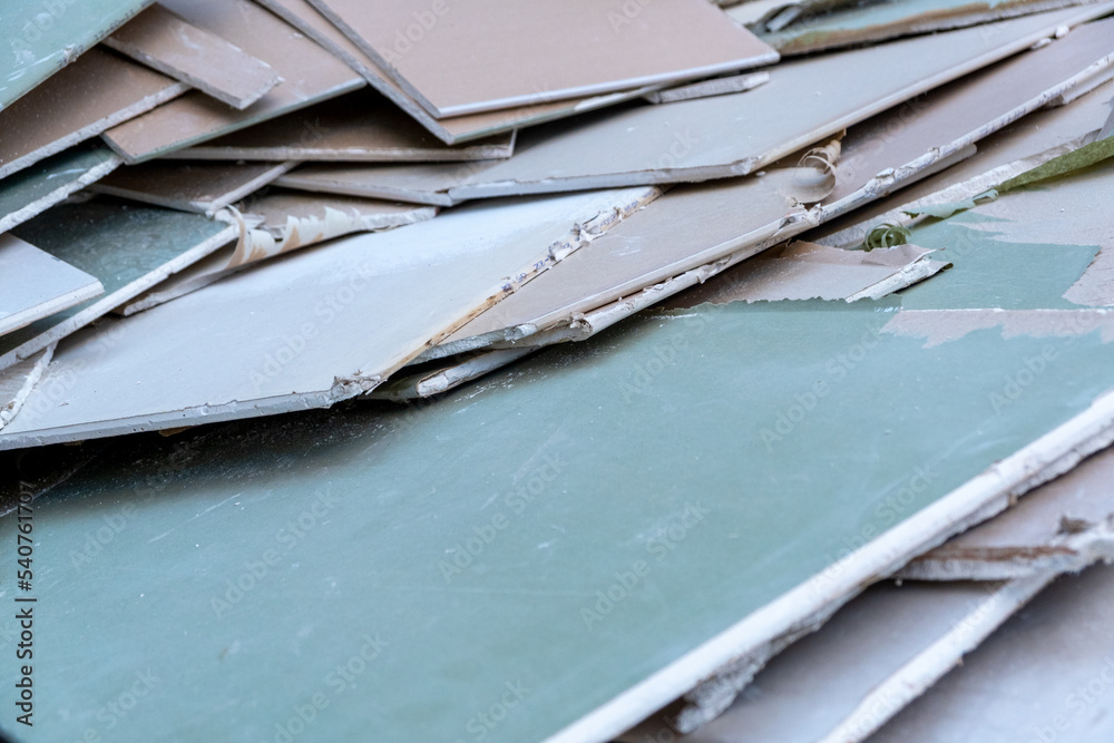 Heap of demolished pieces of used old drywall. Broken gypsum plaster ...