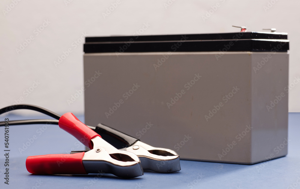 connected bolts charging battery positive pole and negative pole, white ...