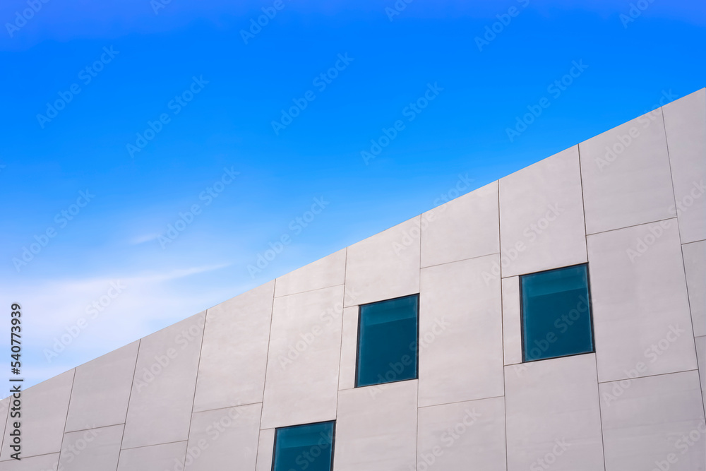 Low angle and side view of glass windows on modern white concrete ...