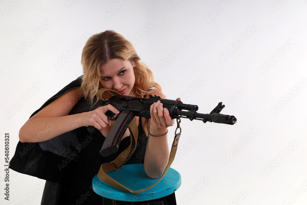 Beautiful woman with assault rifle at the chair Stock Photo | Adobe Stock