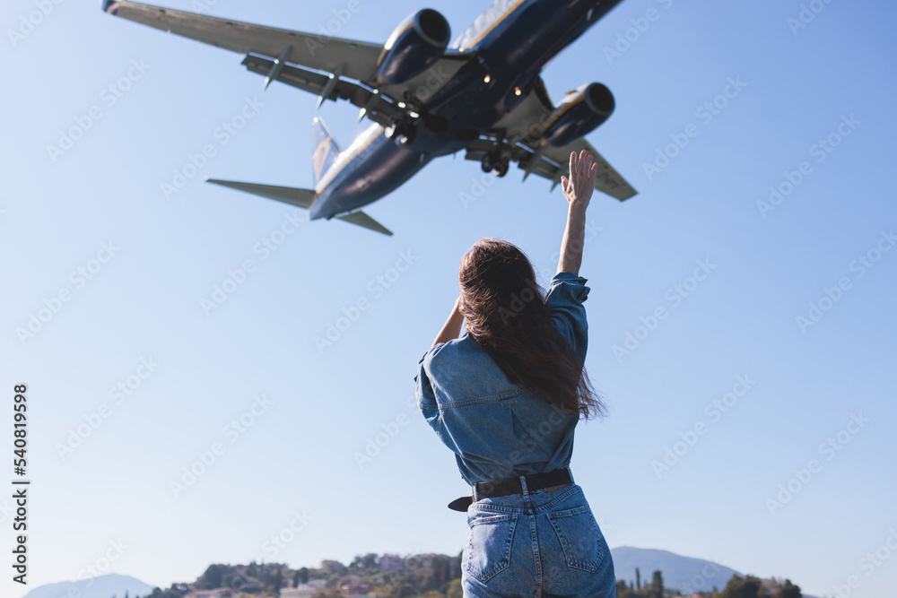 Girl and airplane in flight, landscape with woman standing with hands ...