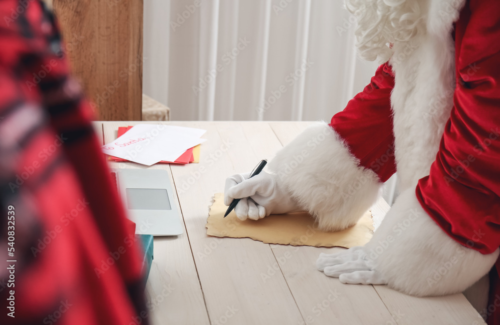 Santa Claus writing letter on wooden standing desk in room Stock Photo ...