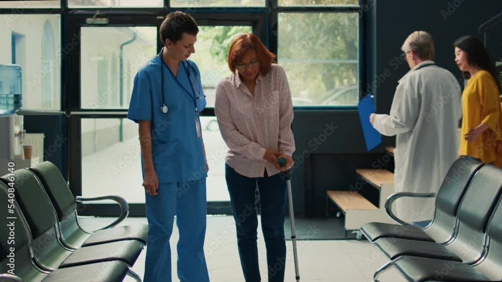 Nurse giving support to patient with impairment trying to walk with ...
