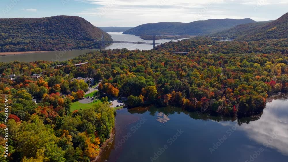 An aerial view of a reflective lake with colorful trees in upstate NY ...