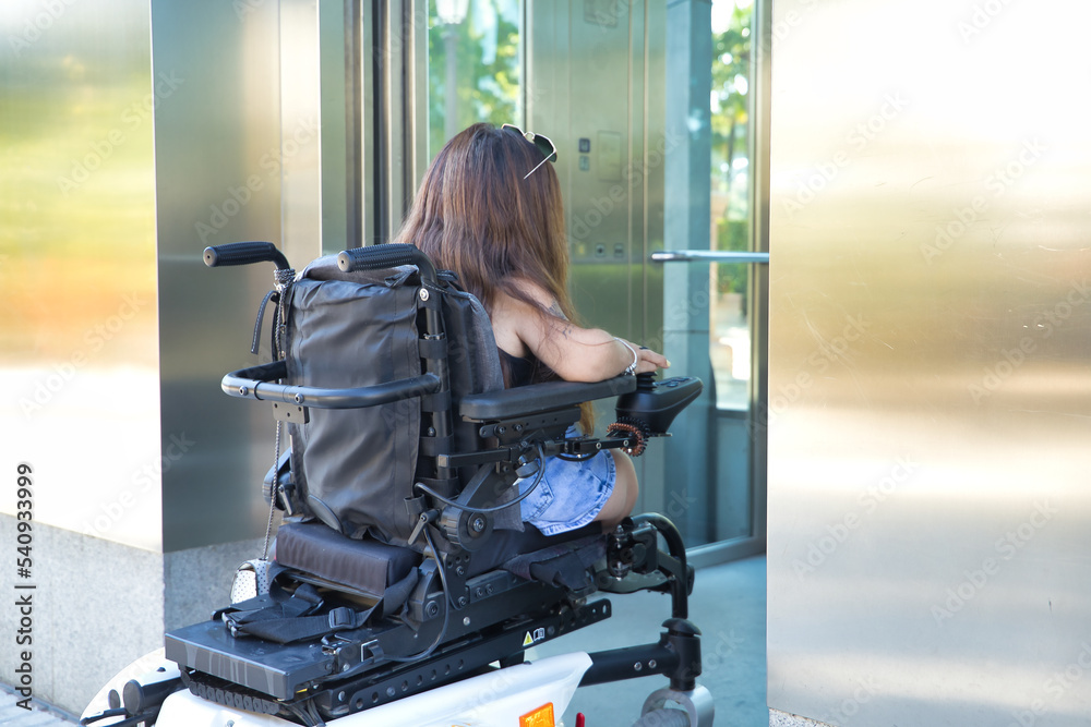 Disabled woman with reduced mobility and small stature in an electric ...
