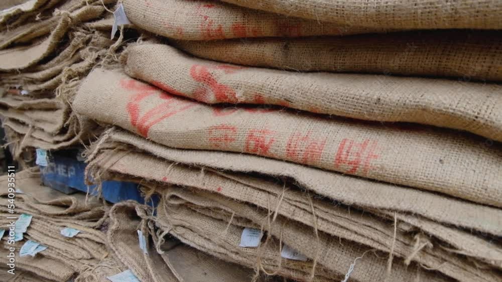 Stacks of used natural hessian jute coffee sacks in a coffee production ...