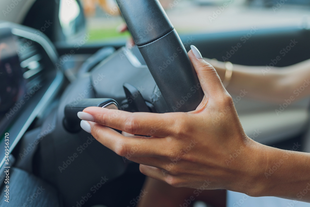 Woman's hand switches the lobes of the gear selector on the steering ...