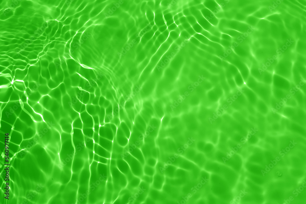 Defocus blurred transparent green colored clear calm water surface ...