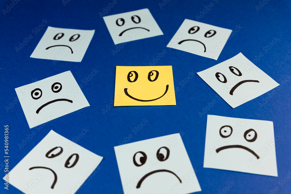 Sticky notes with hand drawn Smiley face and Sad faces on blue ...