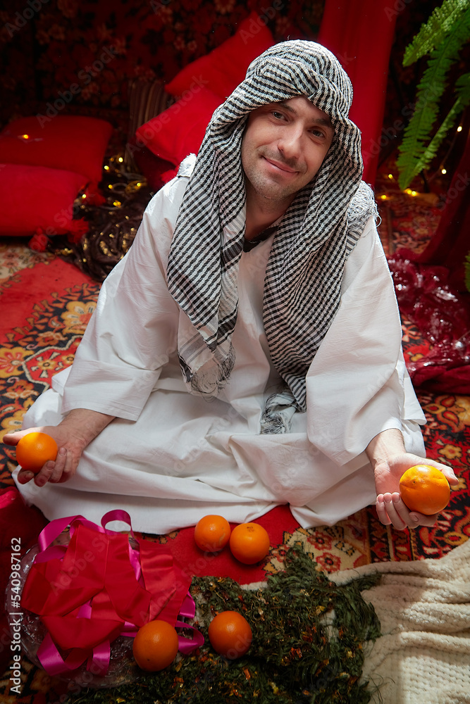 Arab sheikh in a white robe and a headscarf in a boudoir in a room with ...