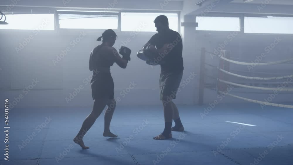 Kickboxing coach training female fighter in gym slow motion, teaching ...