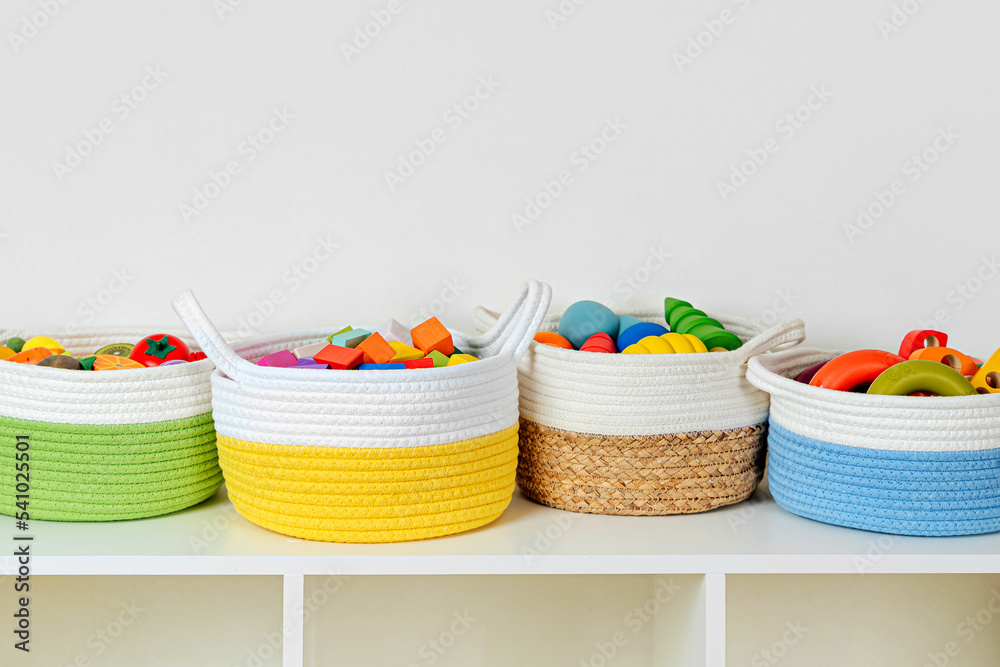 Colorful storage baskets on shelves. White shelving with rainbow wooden ...