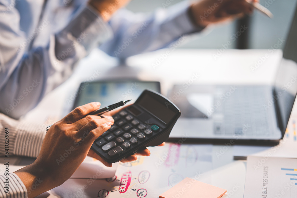 Young colleagues discuss business and analytical price charts using ...