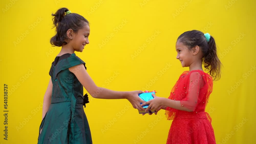 Happy girl gives a gift box, making a surprise. Happy little girl is ...