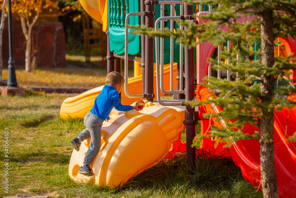 Bright playground in the park. Playground with slides and swings for ...