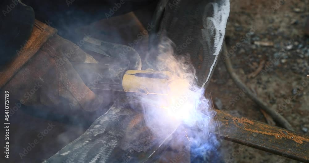 Welder, a person who welds parts of a metal part together. Close-up of ...