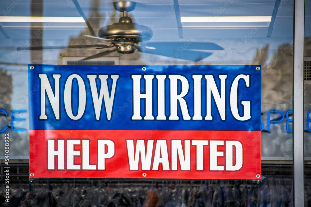 Now Hiring Help Wanted Sign in window of business with ceiling fan ...