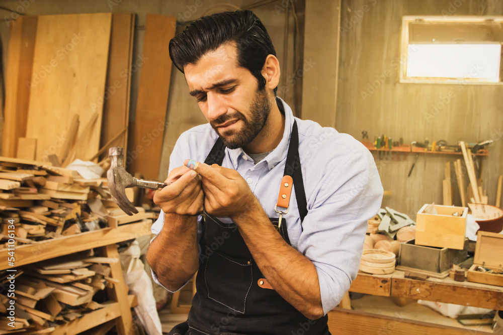 Handsome carpenter worker furniture factory Cried in pain from the ...