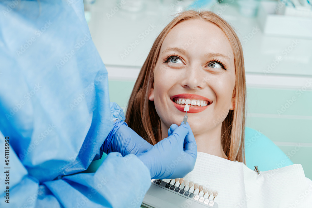 Attractive young woman with natural white teeth in dental clinic. Hands ...