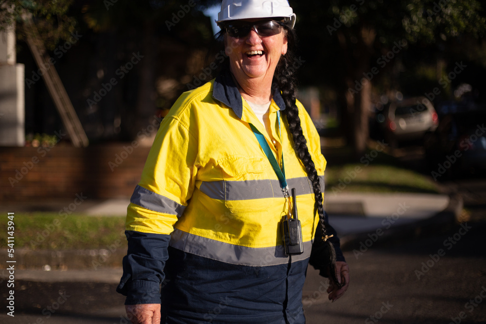Smiling traffic controller woman wearing white helmet and yellow jacket ...