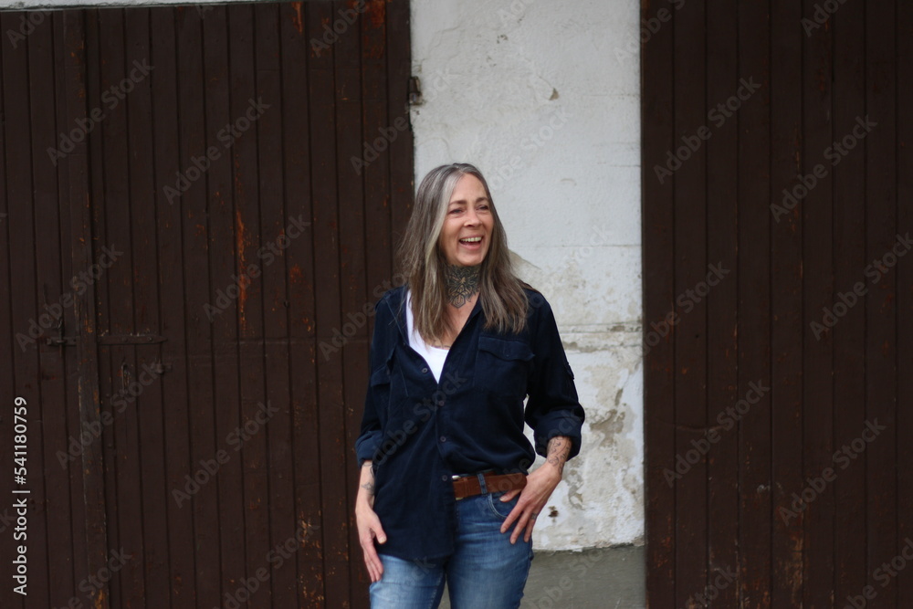 Foto de Frau im besten Alter vor einer Scheune. American Shot, lange ...