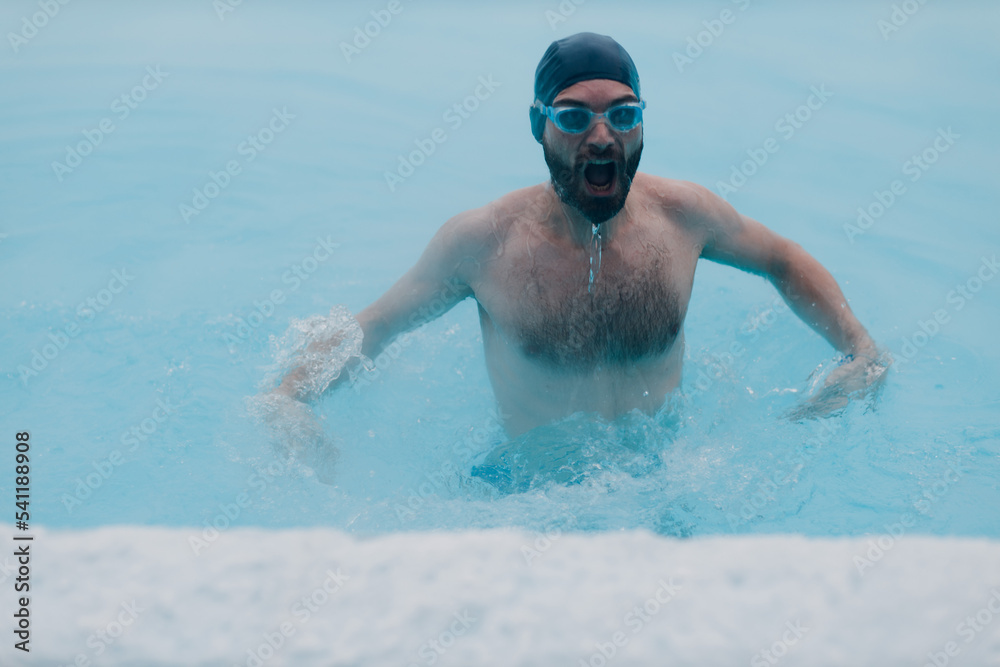 Fit swimmer male training swim in open winter swimming pool with fog ...
