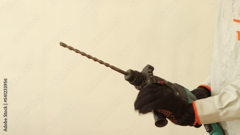 Demonstration of the work of the perforator. Close-up. The hands of a ...