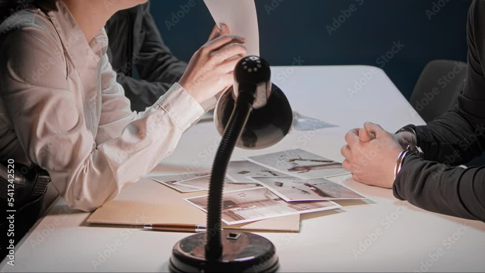 Police officers interrogate murder suspect. Detective cop shows photo ...